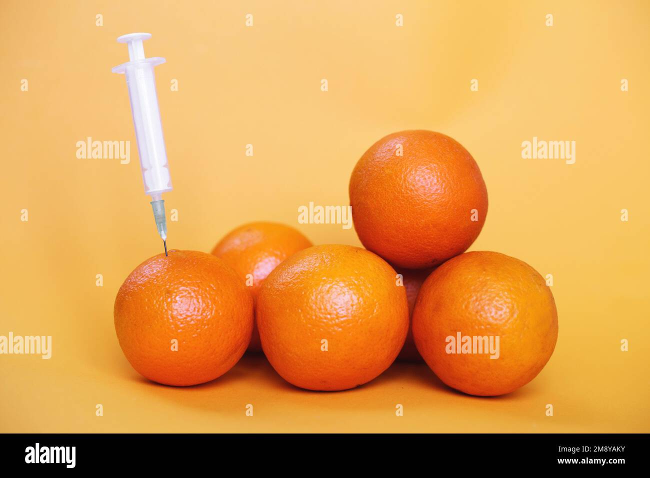 orange fruit with syringe extracting liquid with vitamin C. natural ...