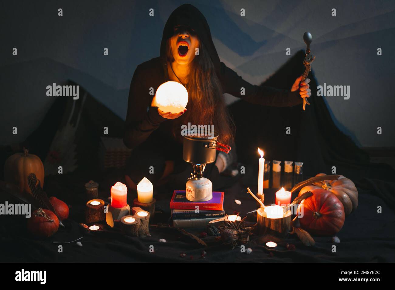 Close up woman casting spell with glowing ball and spoon portrait ...