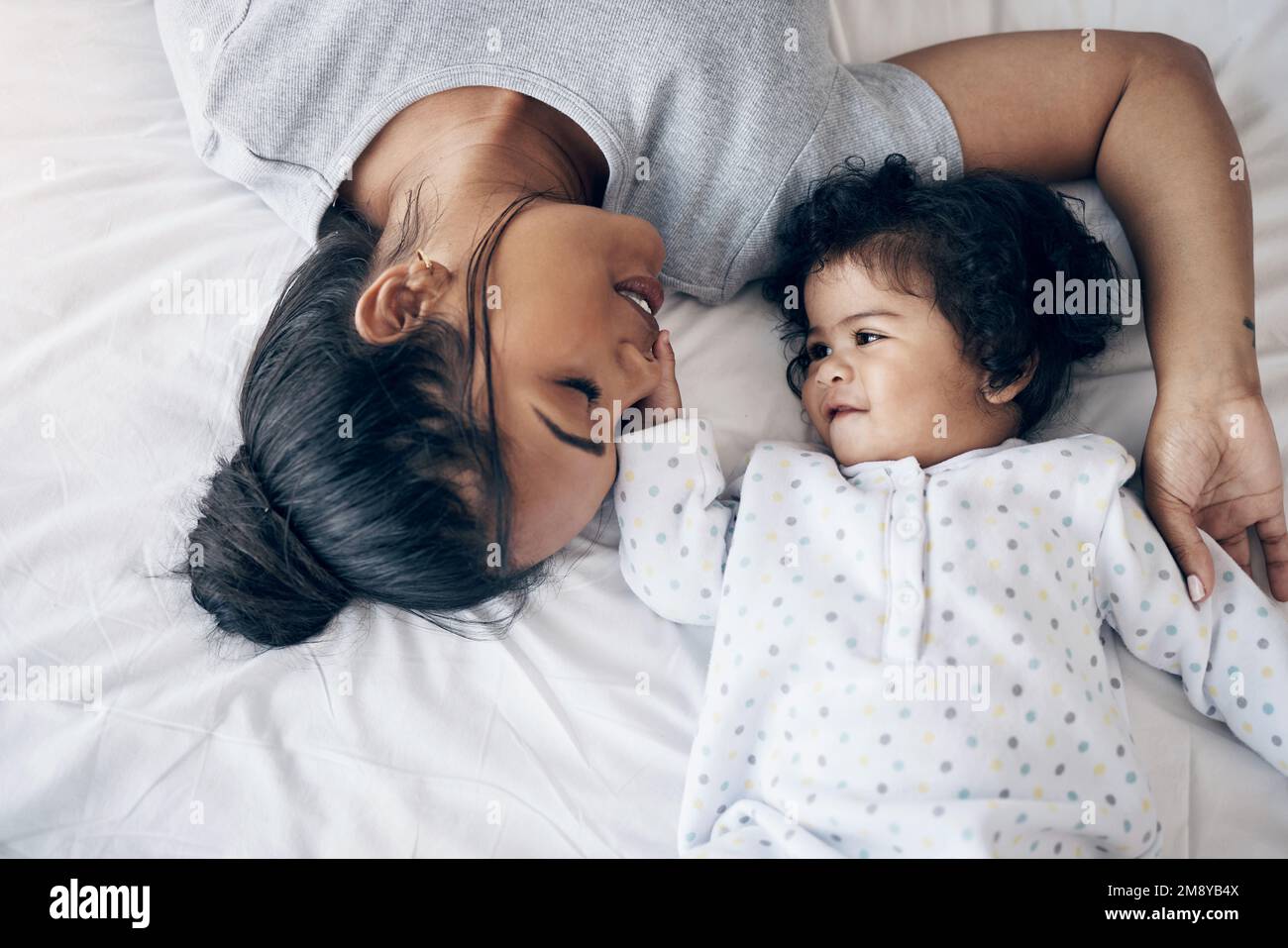 Time for play. a young mother bonding with her baby girl in bed at home ...