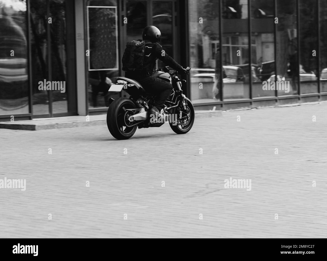 man wearing jeans, leather jacket rides on motorcycle. biker on the ...