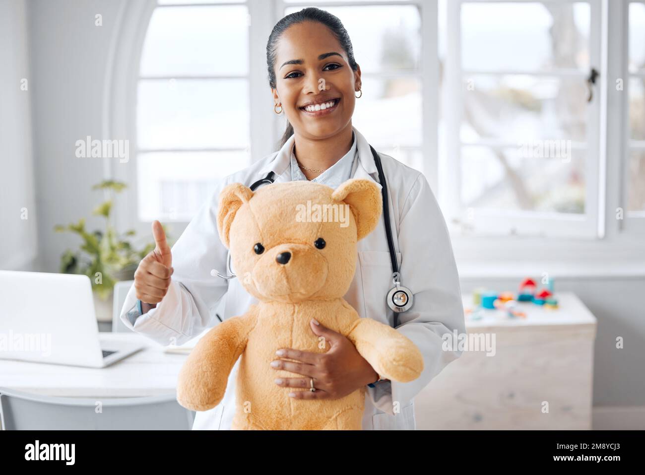 The most rewarding job. a female pediatrician holding a teddy bear ...