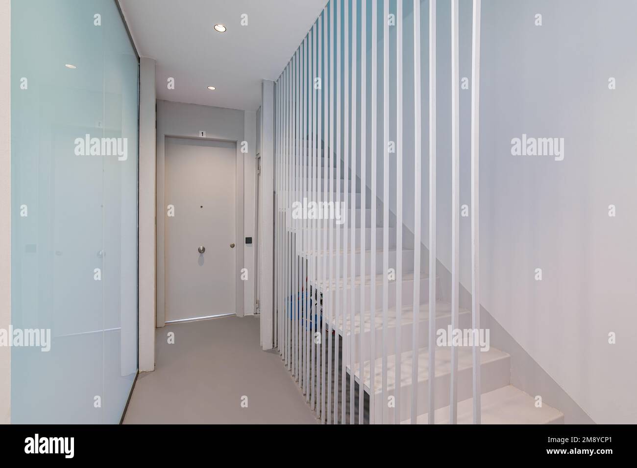 White staircase to the second floor with soft blue lighting in a modern ...