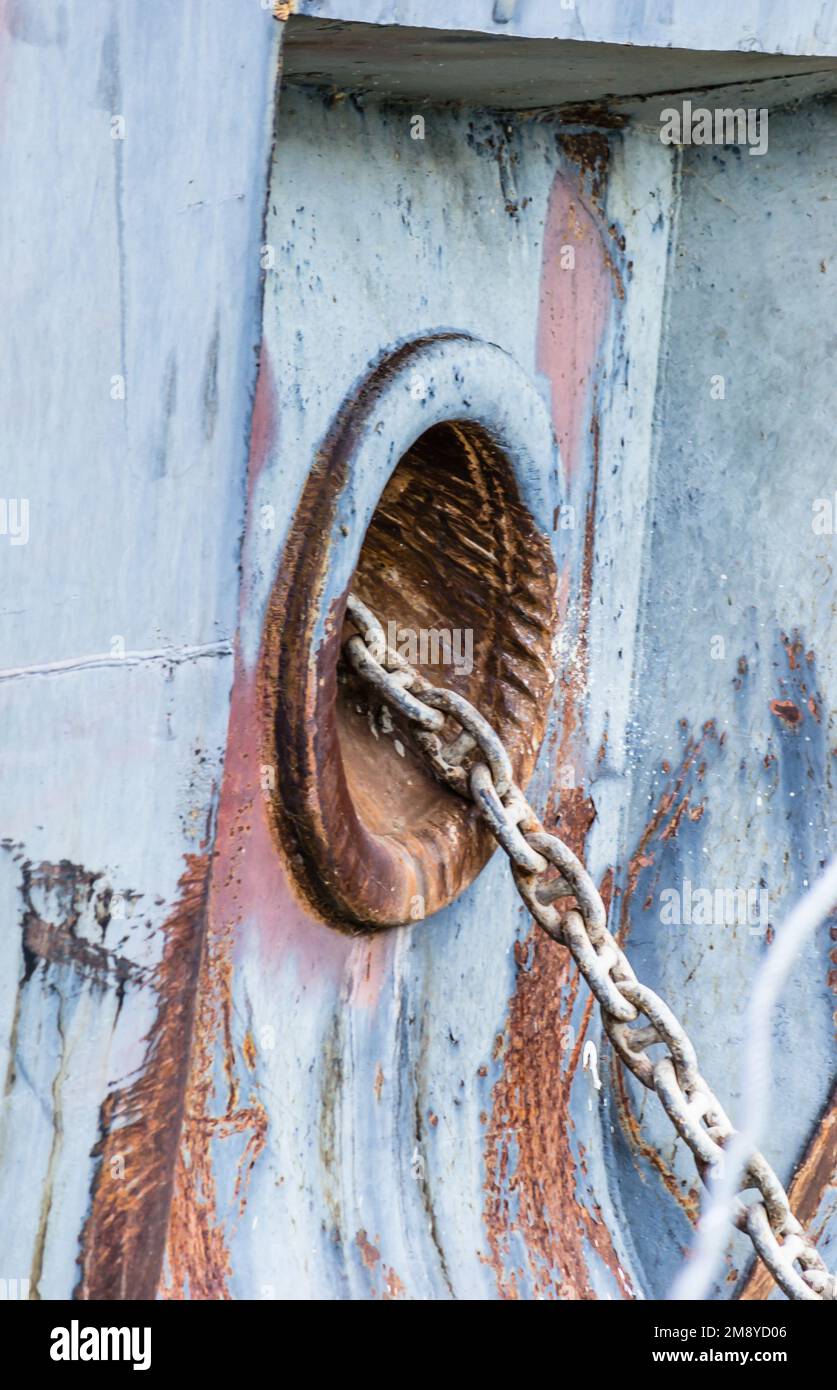 A vertical shot of the anchor hole with a chain of an old stranded ship ...