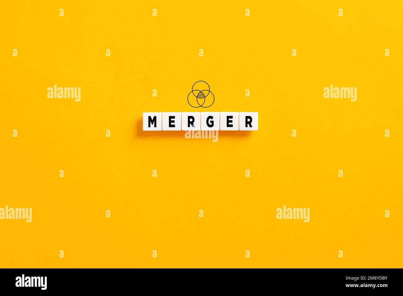 White letter blocks on yellow background with the word merger. Business ...