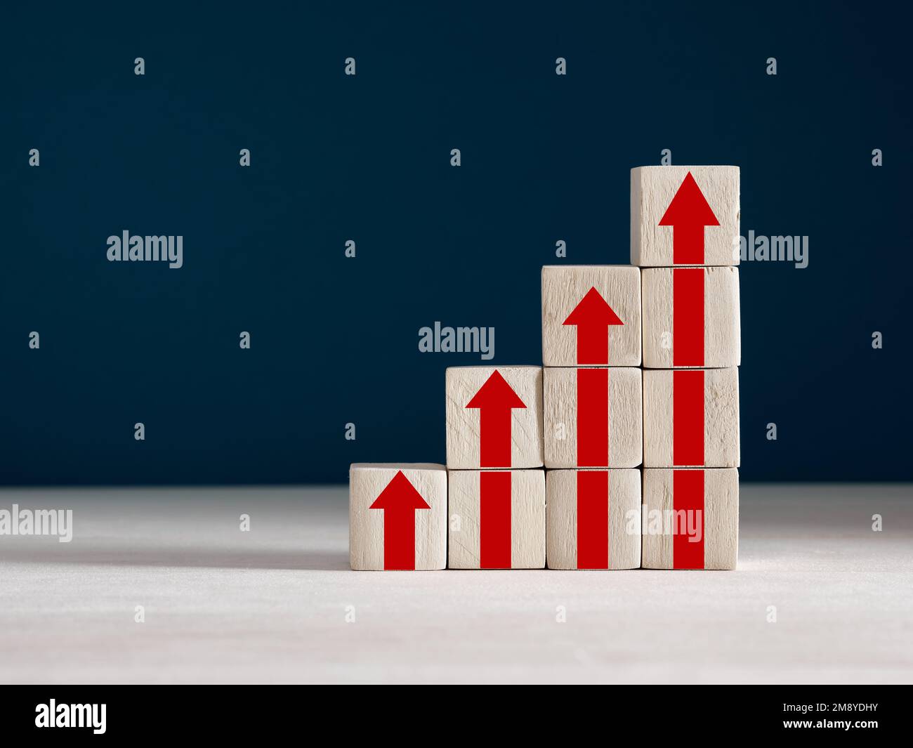 Stack of wooden cubes with red arrows going up. The process of ...