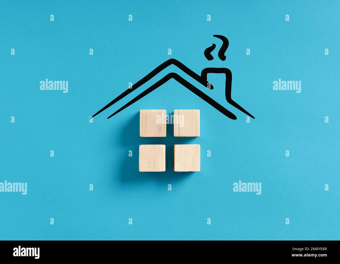 House made of wooden blocks on blue background. Building a home concept ...