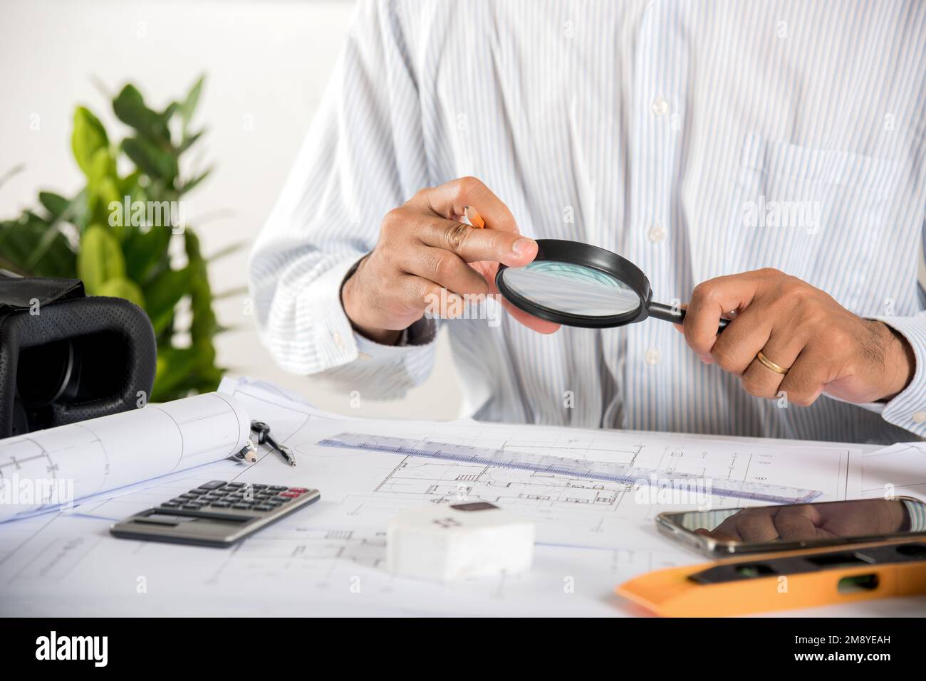 Architectural interior designer working holding magnifying glass and ...