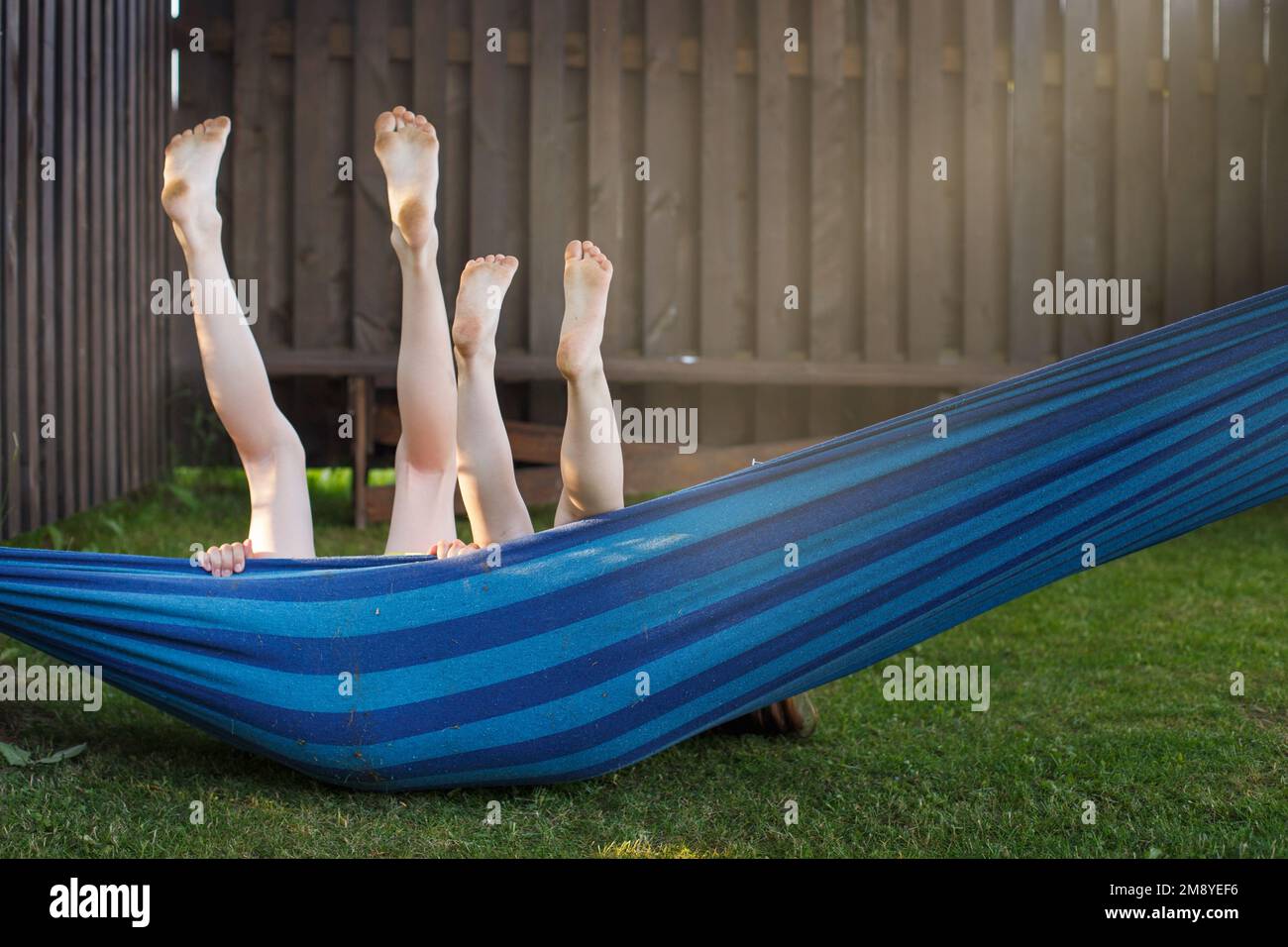 happy kids relaxing in a hammock outdoor. children's feet barefoot. Holidays vacation Stock ...