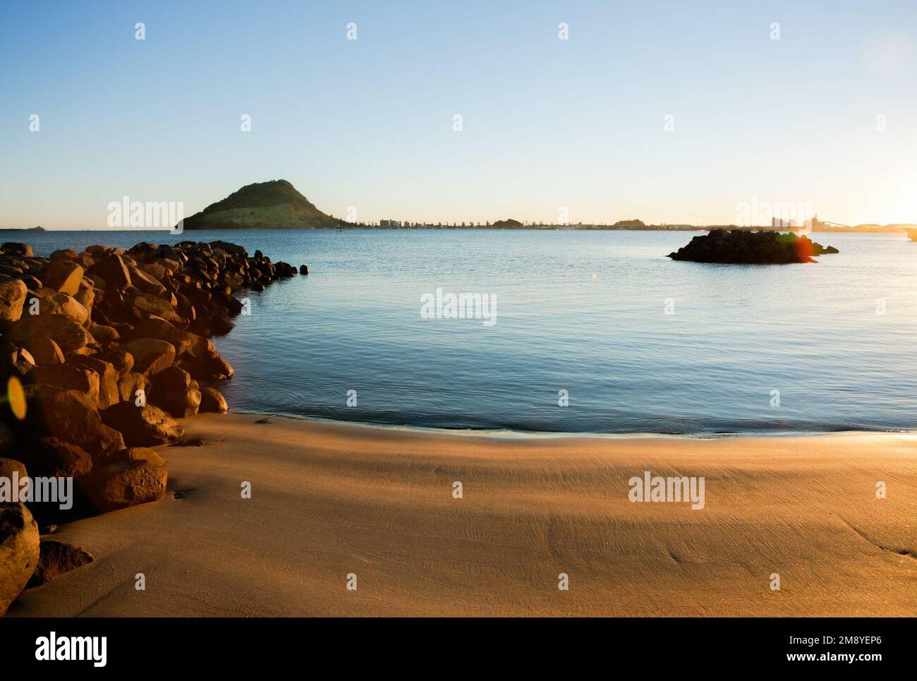 Small bay and rock groyne and view to Mount Maunganui across Tauranga ...