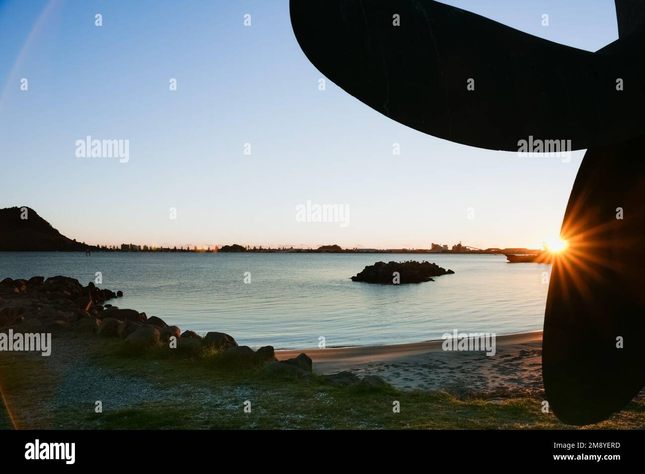 Sunburst at sunrise with propeller and landscape in silhouette at ...