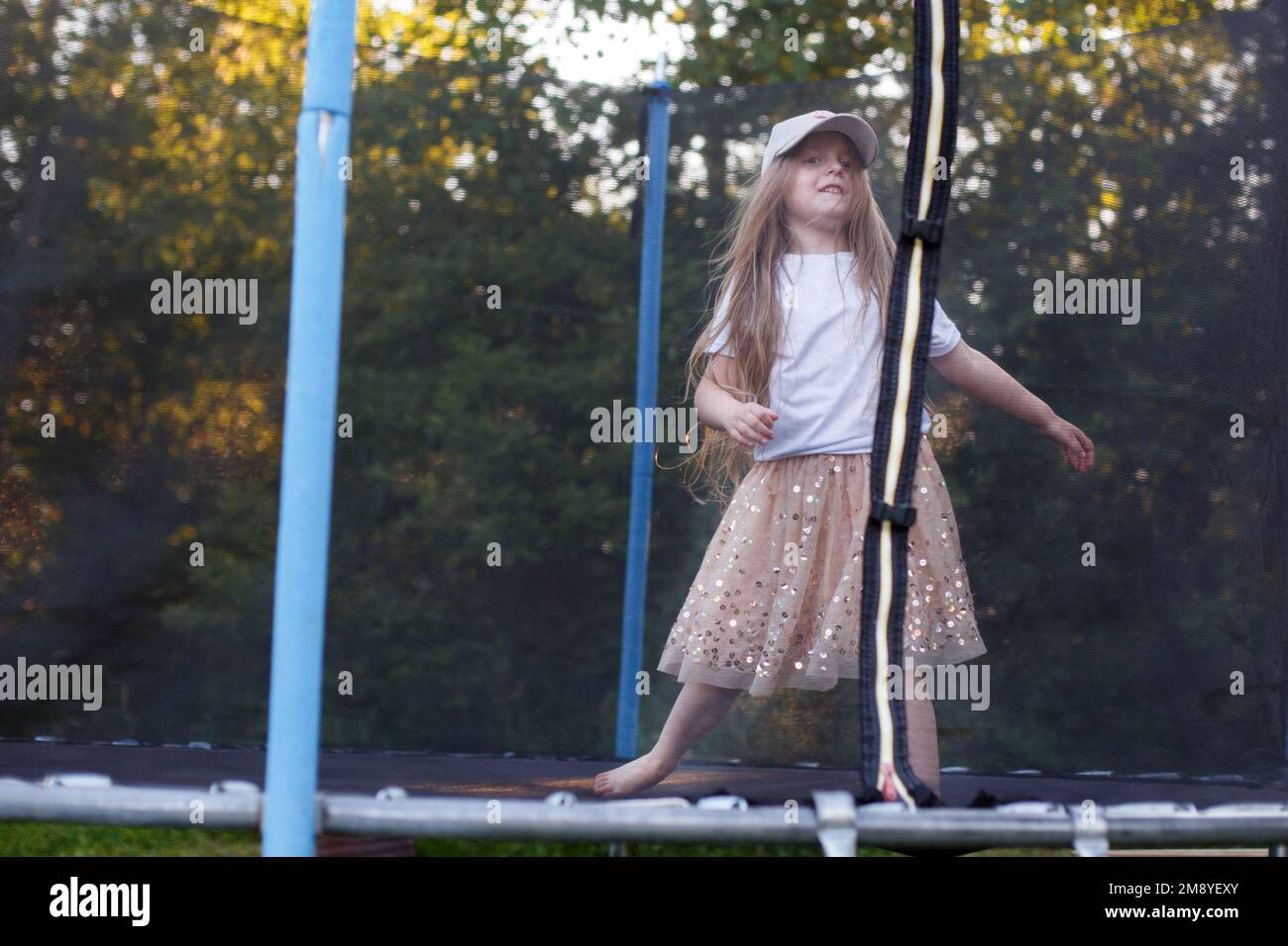 a Little child girl jumping on the trampoline in the back yard Stock ...