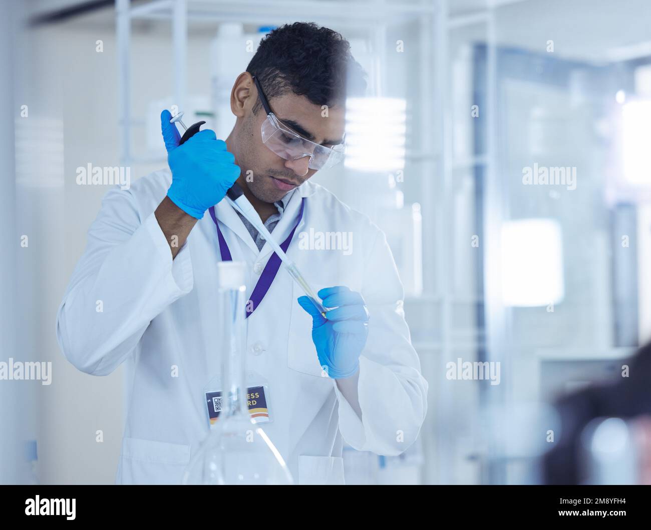Slow and steady. a male scientist decanting samples into test tubes ...