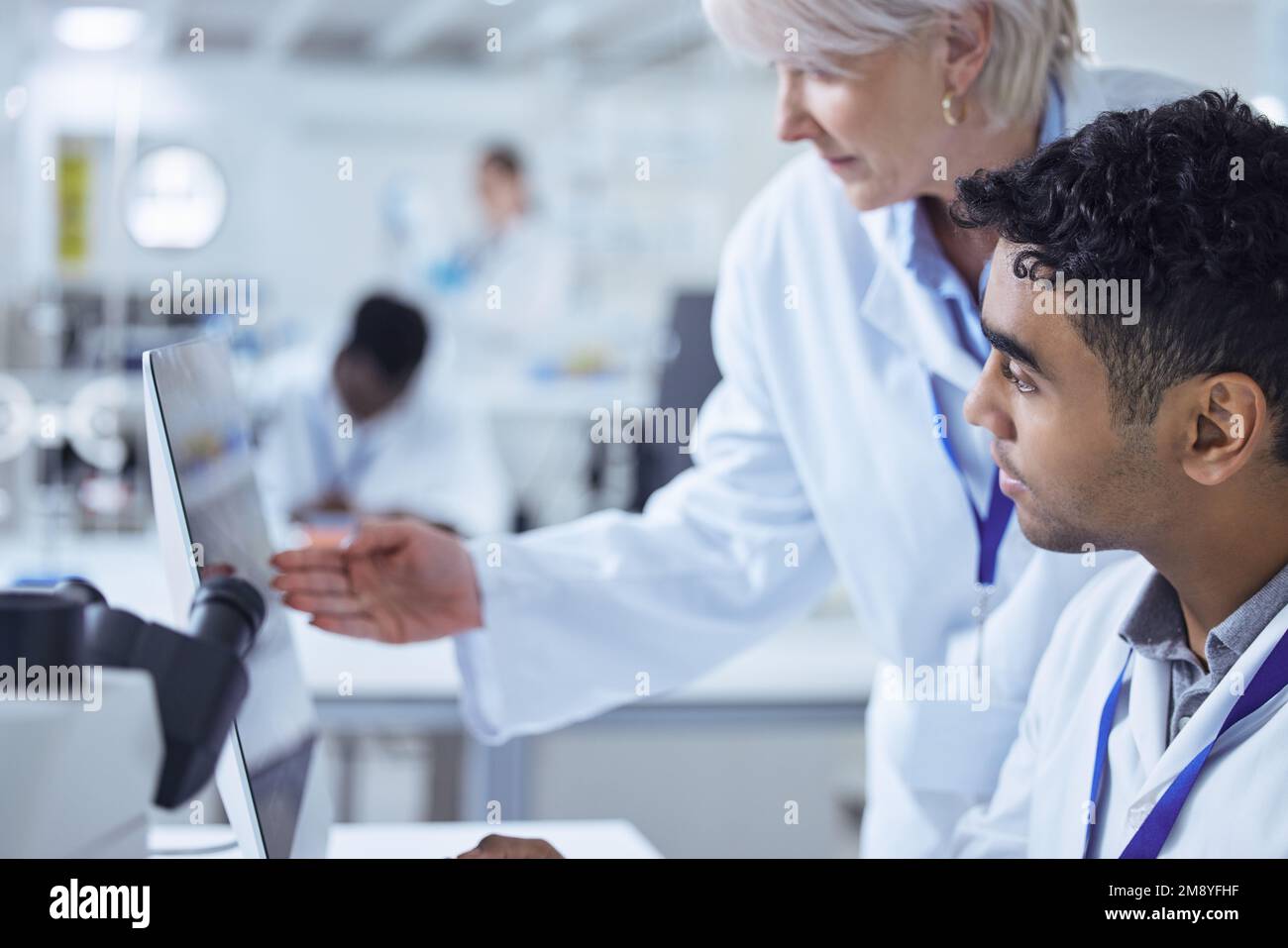 Mature male scientist teaching female hi-res stock photography and ...