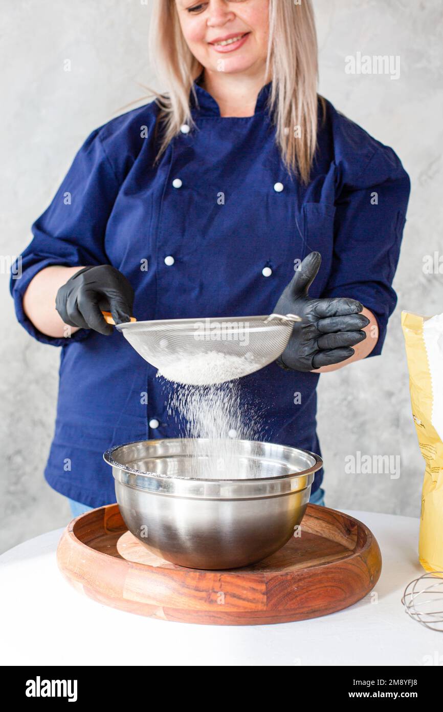 Woman sifting flour through old sieve on kitchen board Stock Photo - Alamy