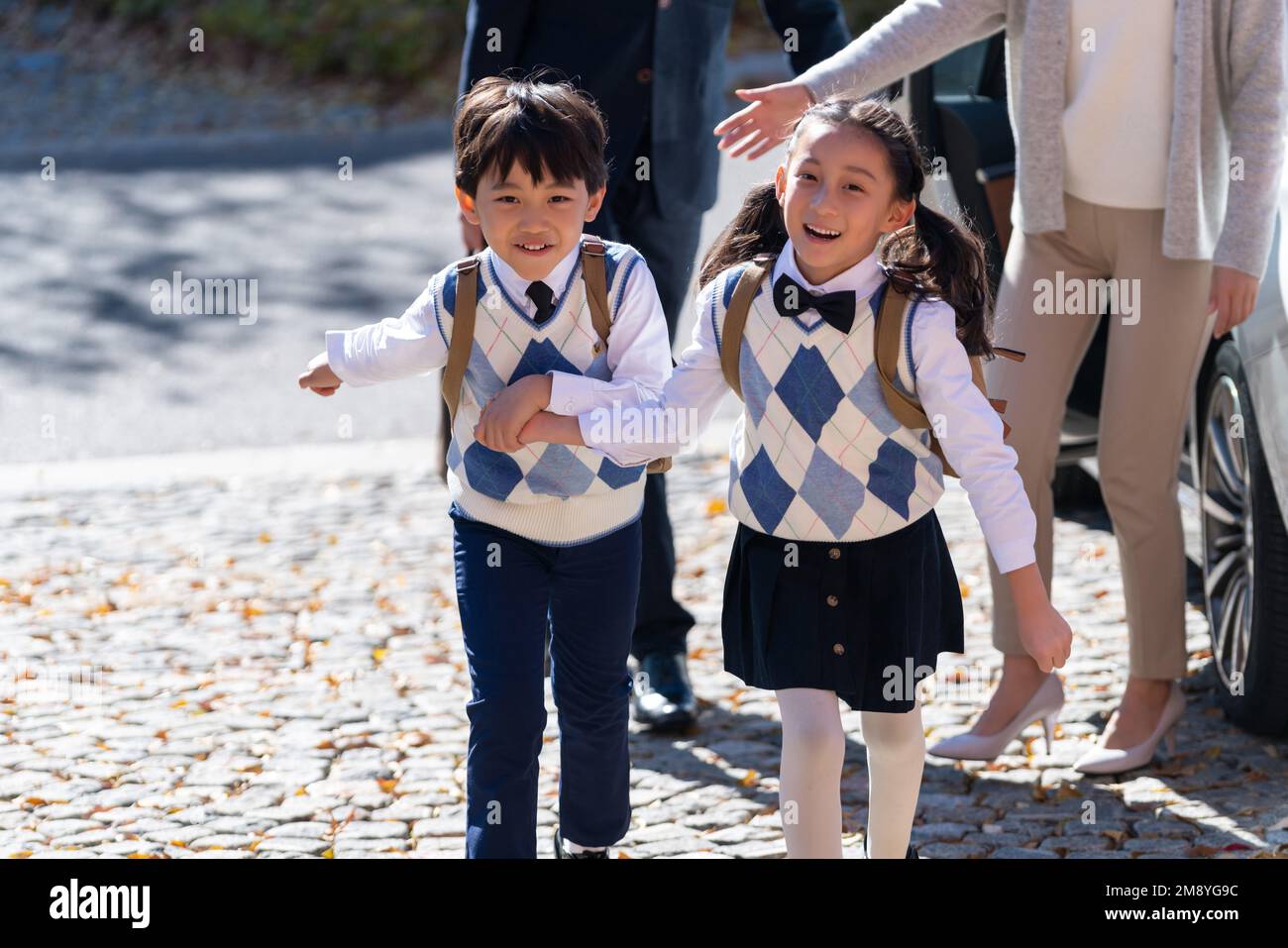 A young couple pick up the kids from school Stock Photo - Alamy