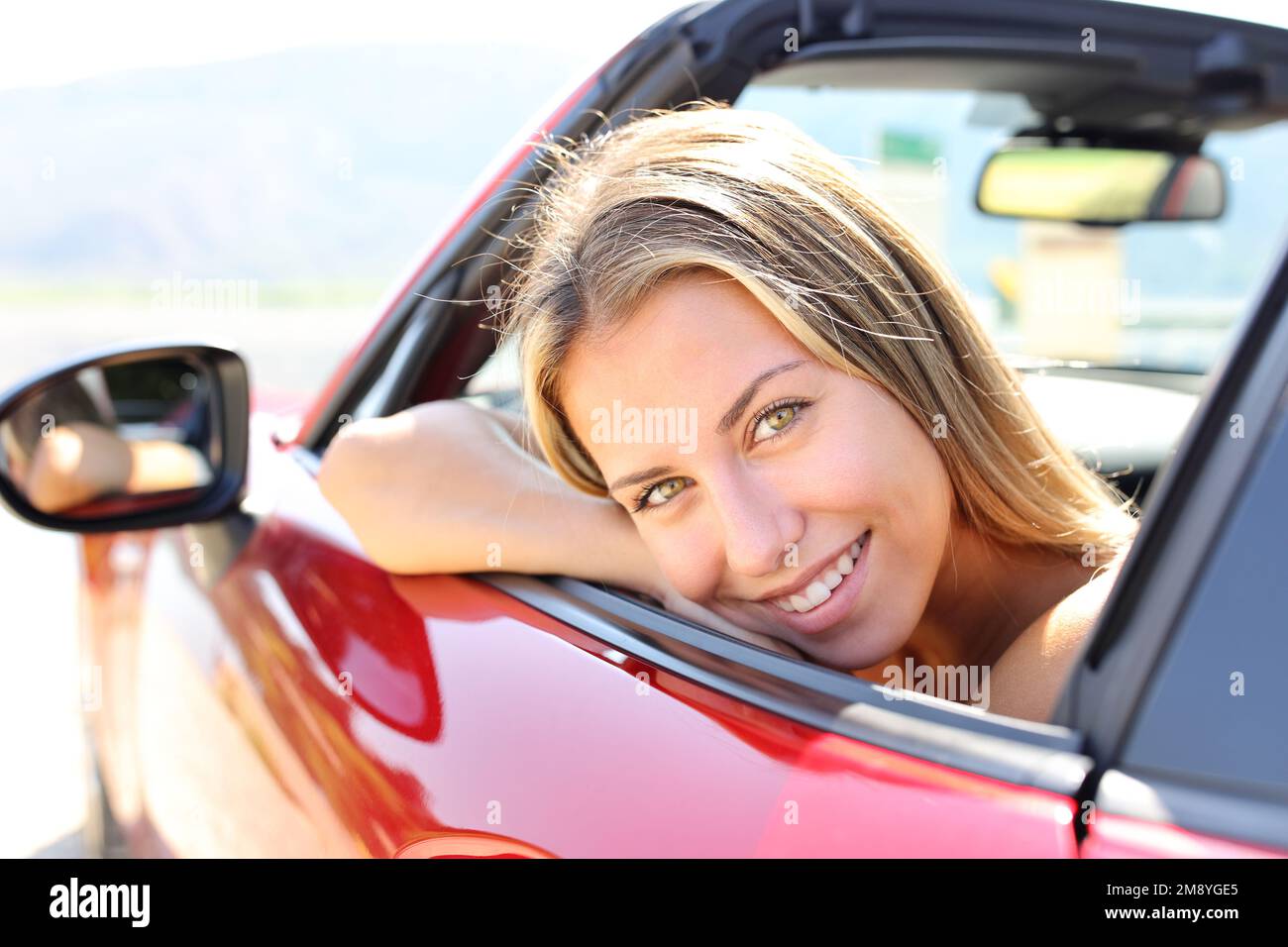 Happy convertible car driver looks at you smiling Stock Photo - Alamy