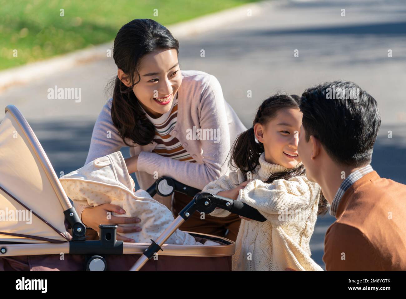 A young couple walk pushing a stroller Stock Photo - Alamy