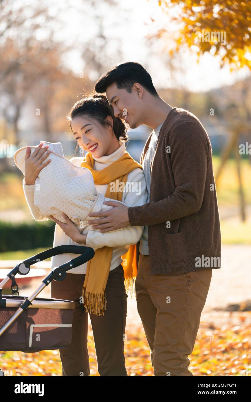 A young couple walk pushing a stroller Stock Photo - Alamy