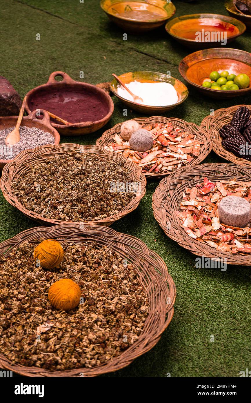 A vertical shot of woolen yarn balls with their natural dye sources on ...
