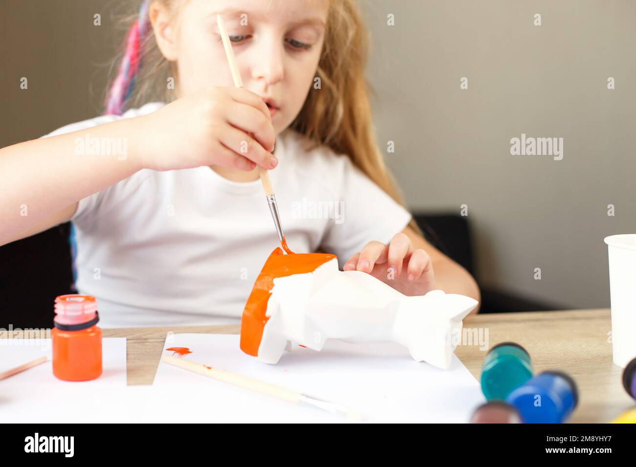 a little girl paints a toy fox made of clay. DIY concept Stock Photo ...