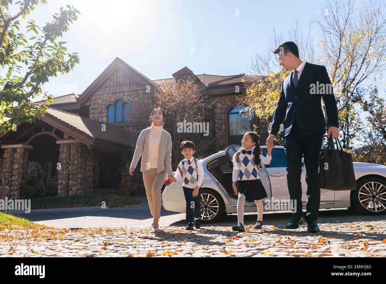 A young couple pick up the kids from school Stock Photo - Alamy