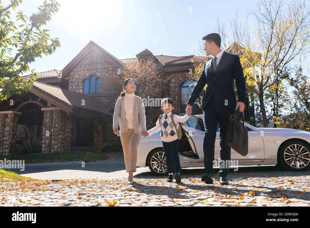 A young couple pick up the kids from school Stock Photo - Alamy