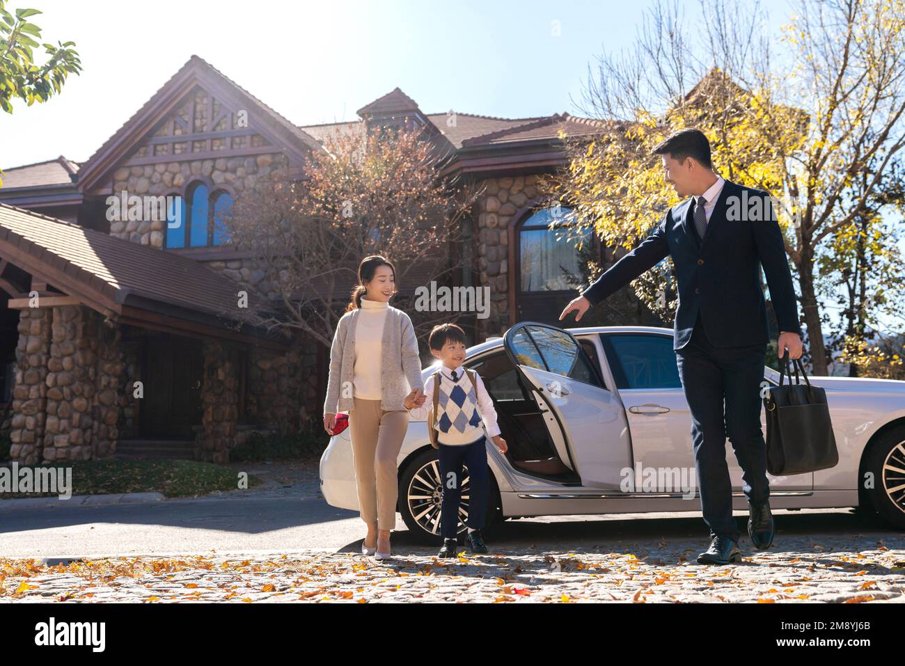 A young couple pick up the kids from school Stock Photo - Alamy