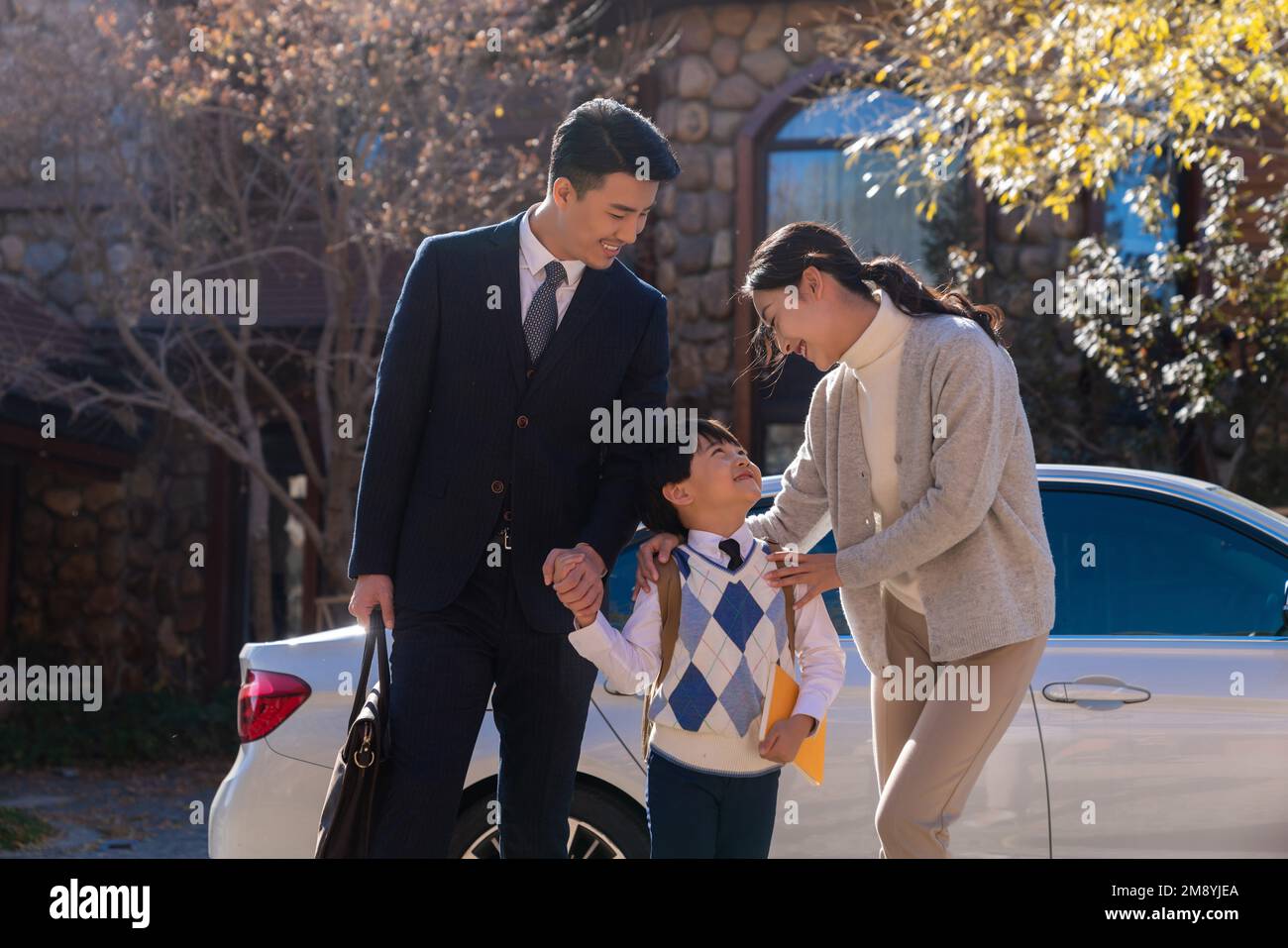 A young couple pick up the kids from school Stock Photo - Alamy