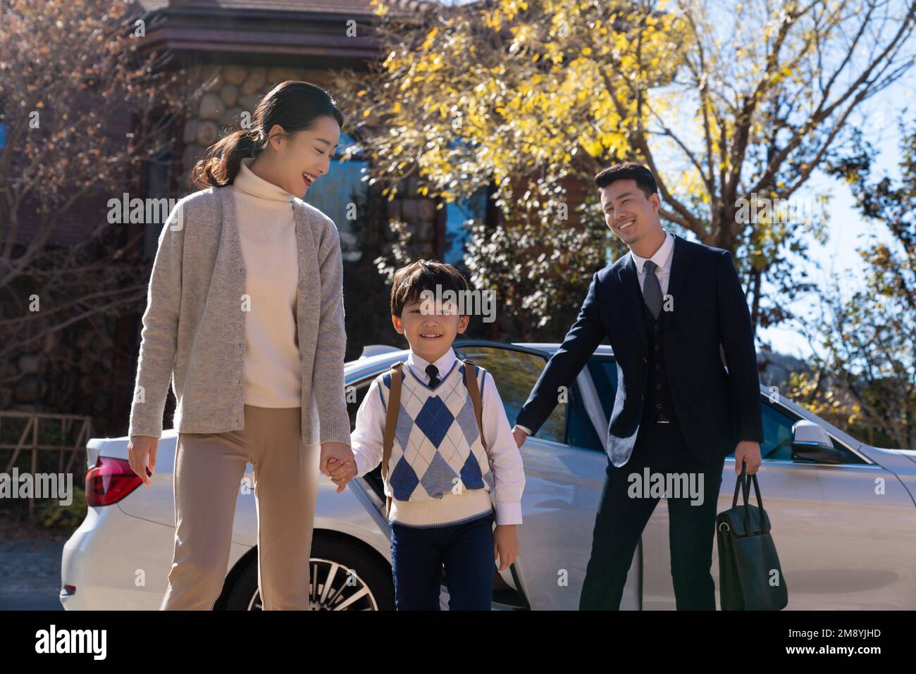 A young couple pick up the kids from school Stock Photo - Alamy