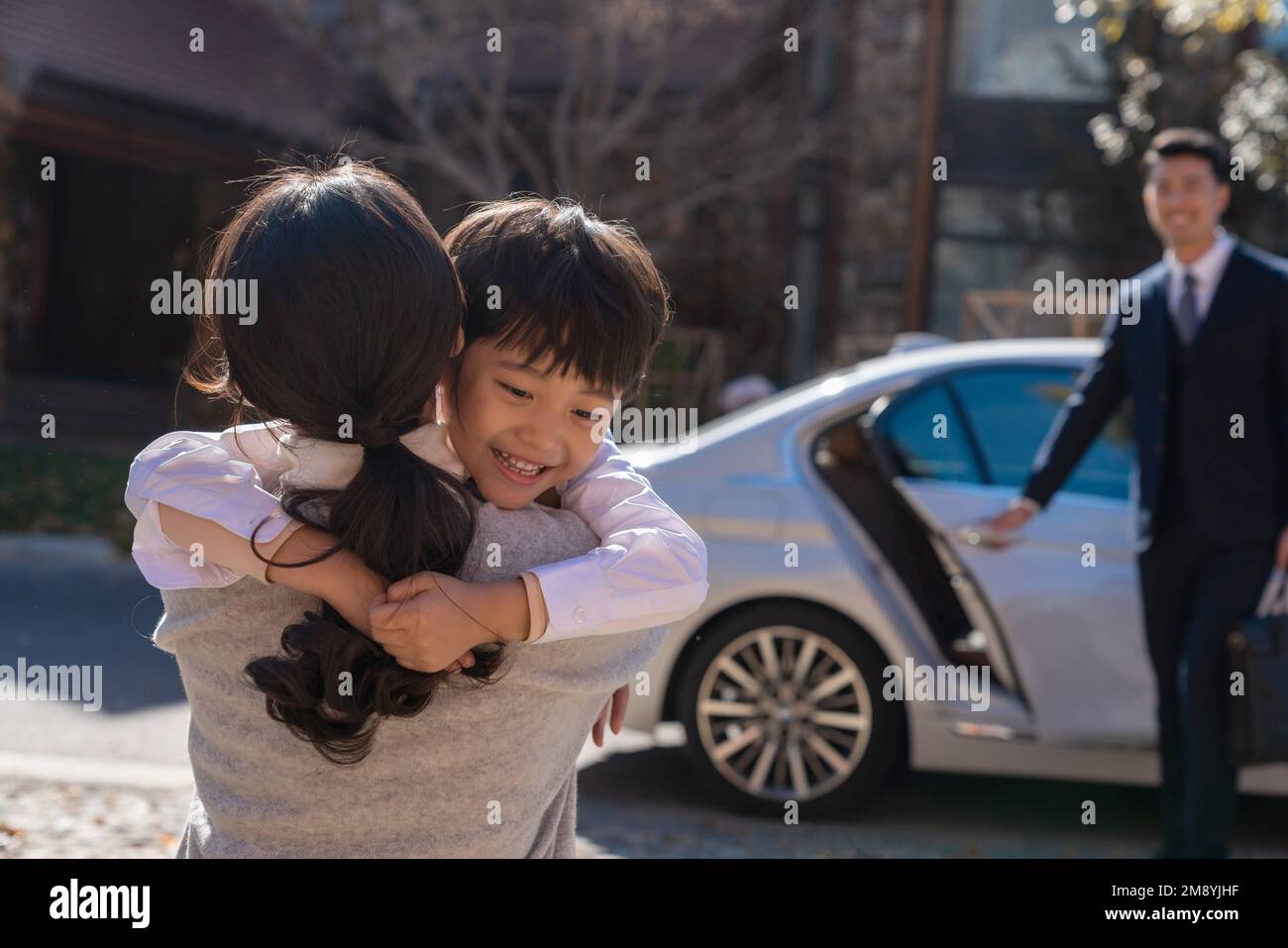 A young couple pick up the kids from school Stock Photo - Alamy