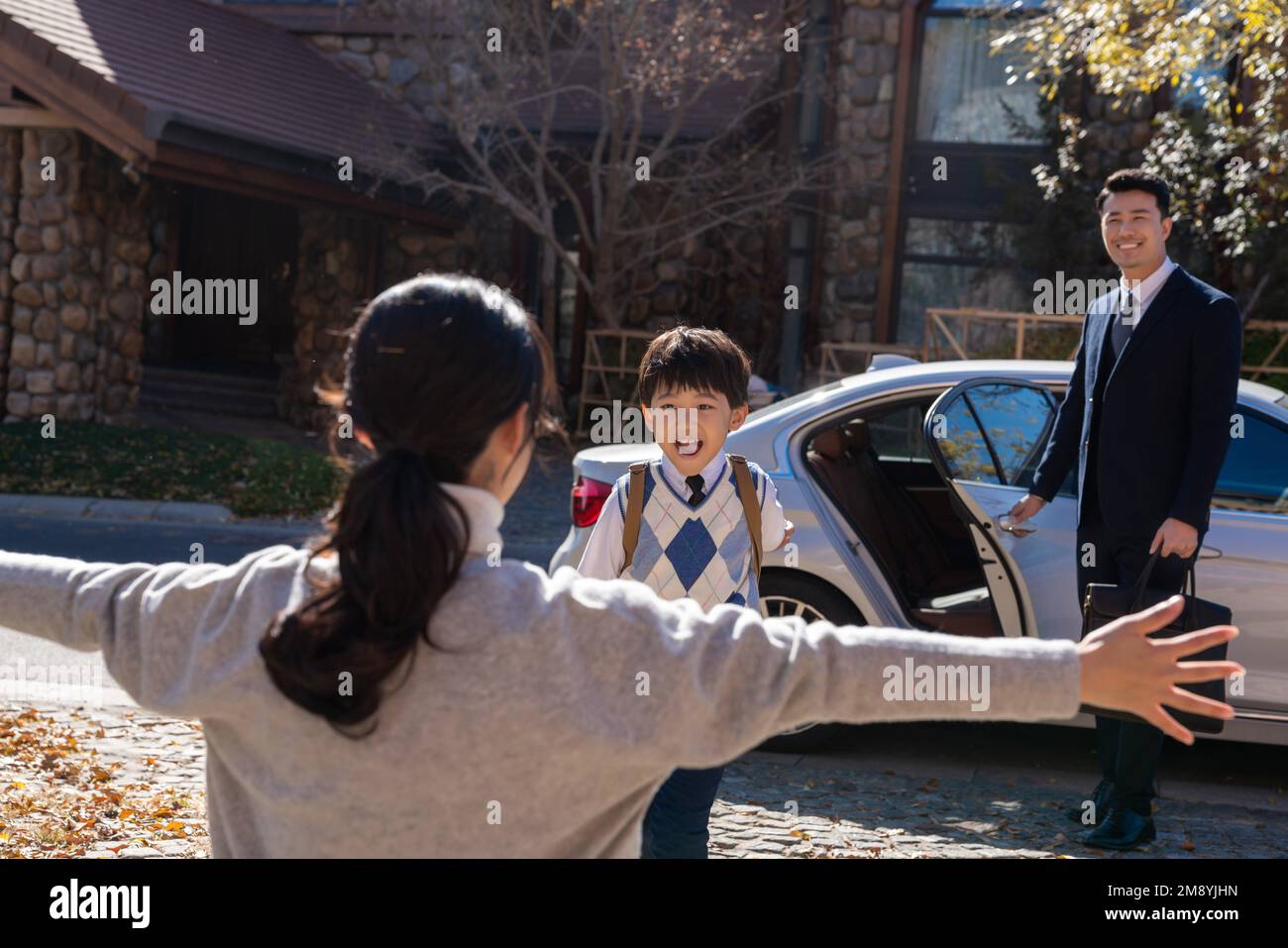 A young couple pick up the kids from school Stock Photo - Alamy
