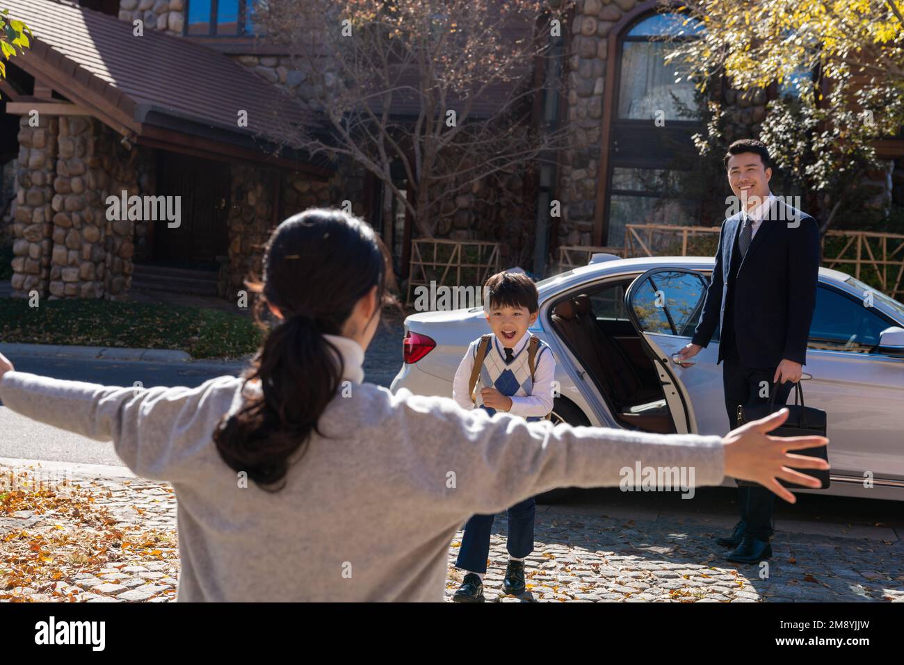 A young couple pick up the kids from school Stock Photo - Alamy