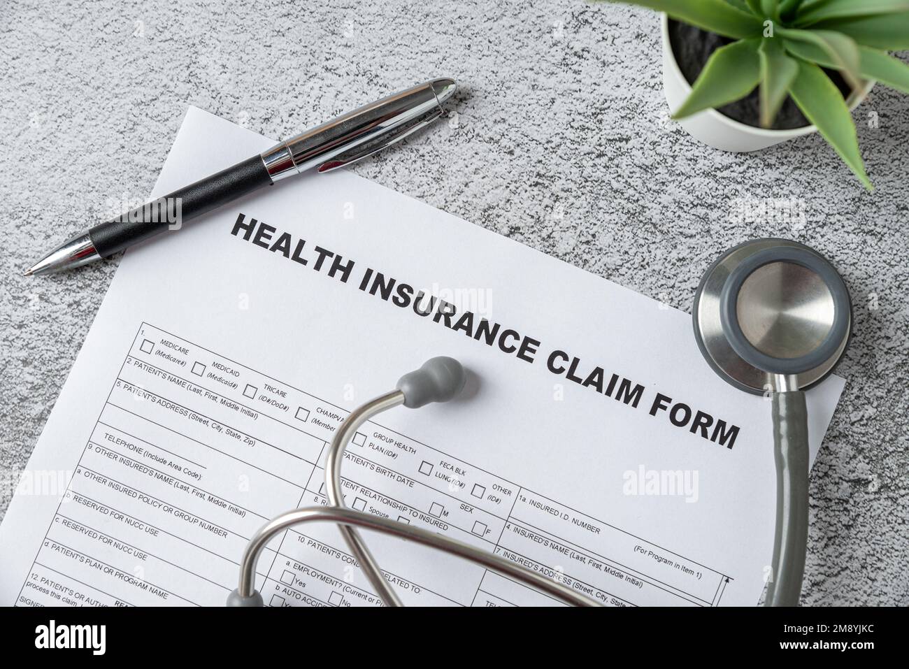 Top view of doctor's stethoscope, pen and health insurance claim form ...