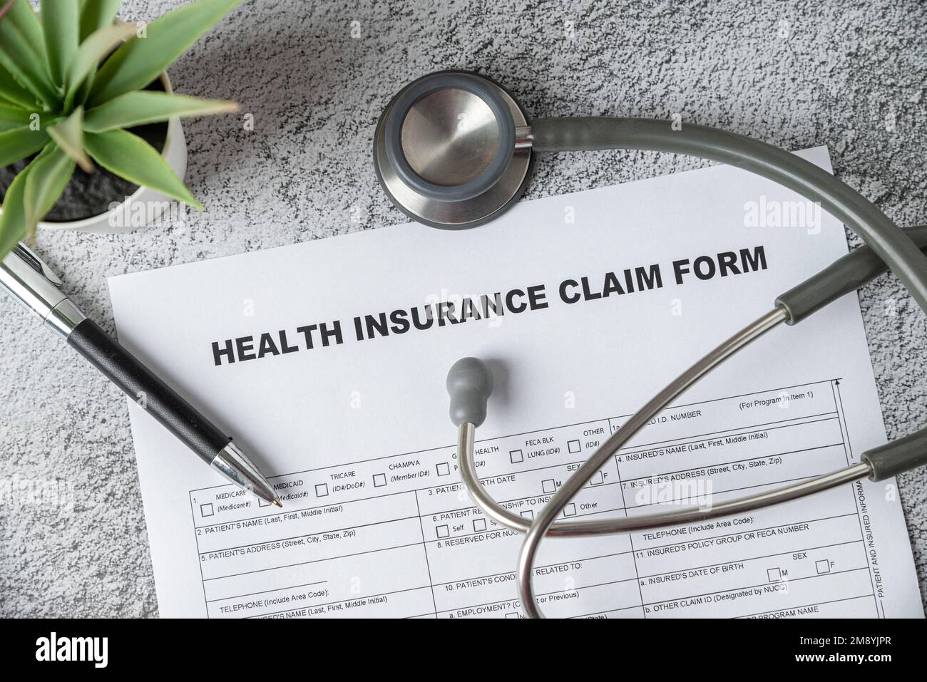 Top view of doctor's stethoscope, pen and health insurance claim form ...