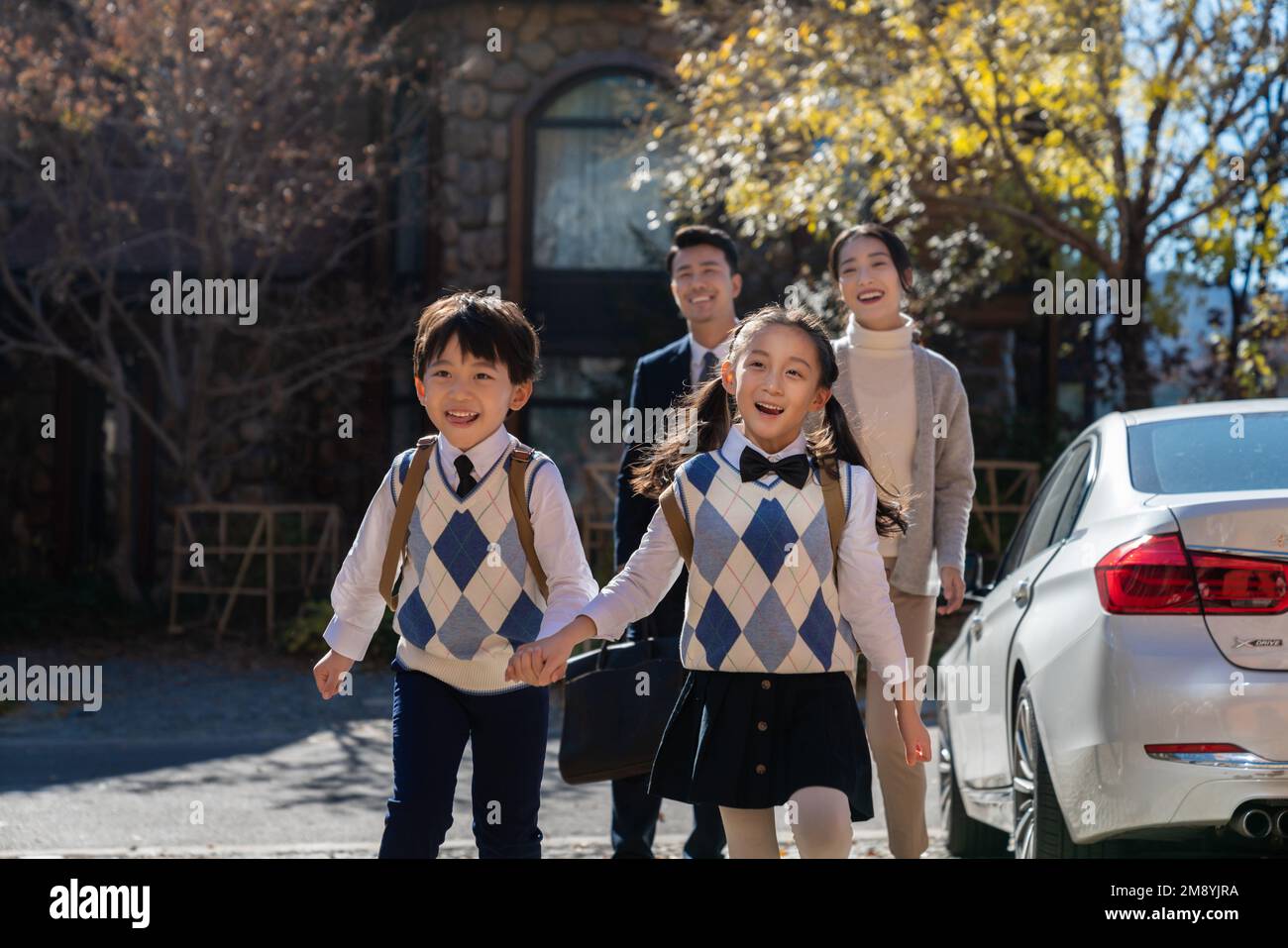 A young couple pick up the kids from school Stock Photo - Alamy