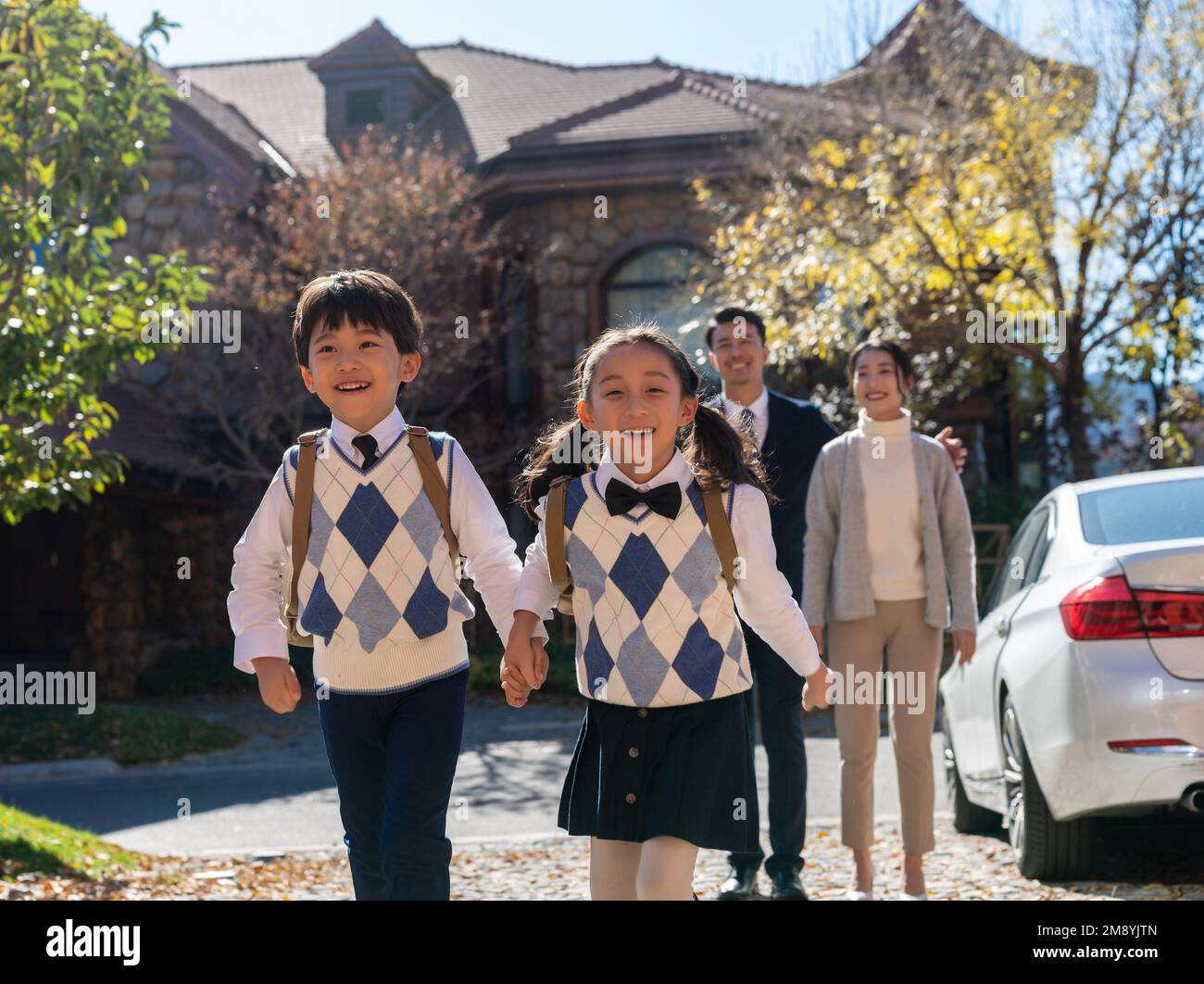 A young couple pick up the kids from school Stock Photo - Alamy