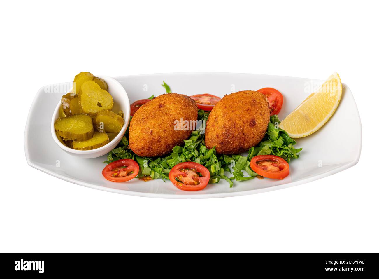 Kibbeh or icli kofte on a white background with pickles and salad Stock ...
