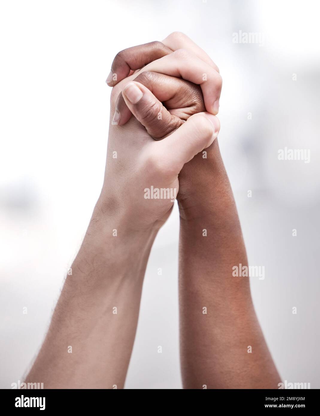 Together we build each other up. two protestors joining hands in unity ...