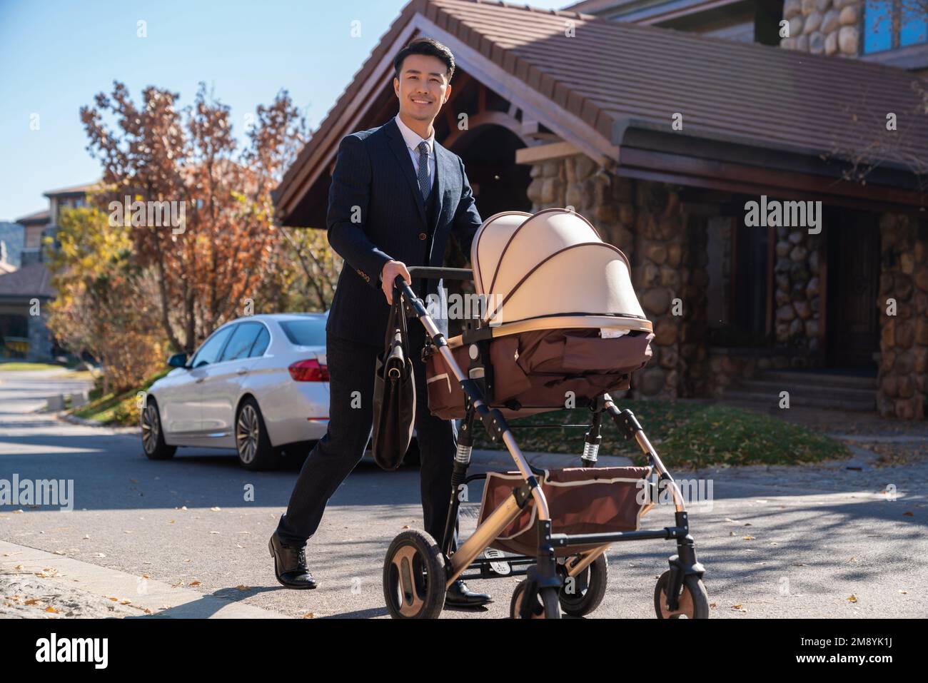 A young business man pushing a pram Stock Photo - Alamy