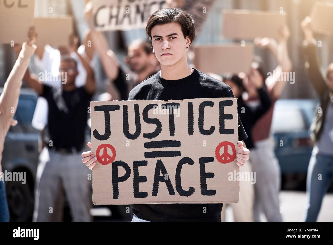 Fighting for the rights of others. a young man holding up a sign during ...