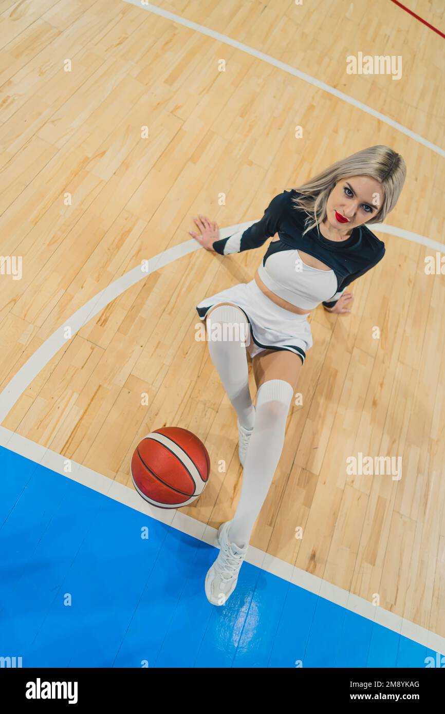 High Angle Shot Of A Blond Cheerleader Sitting On The Floor With Her Hands Put Also On The Floor