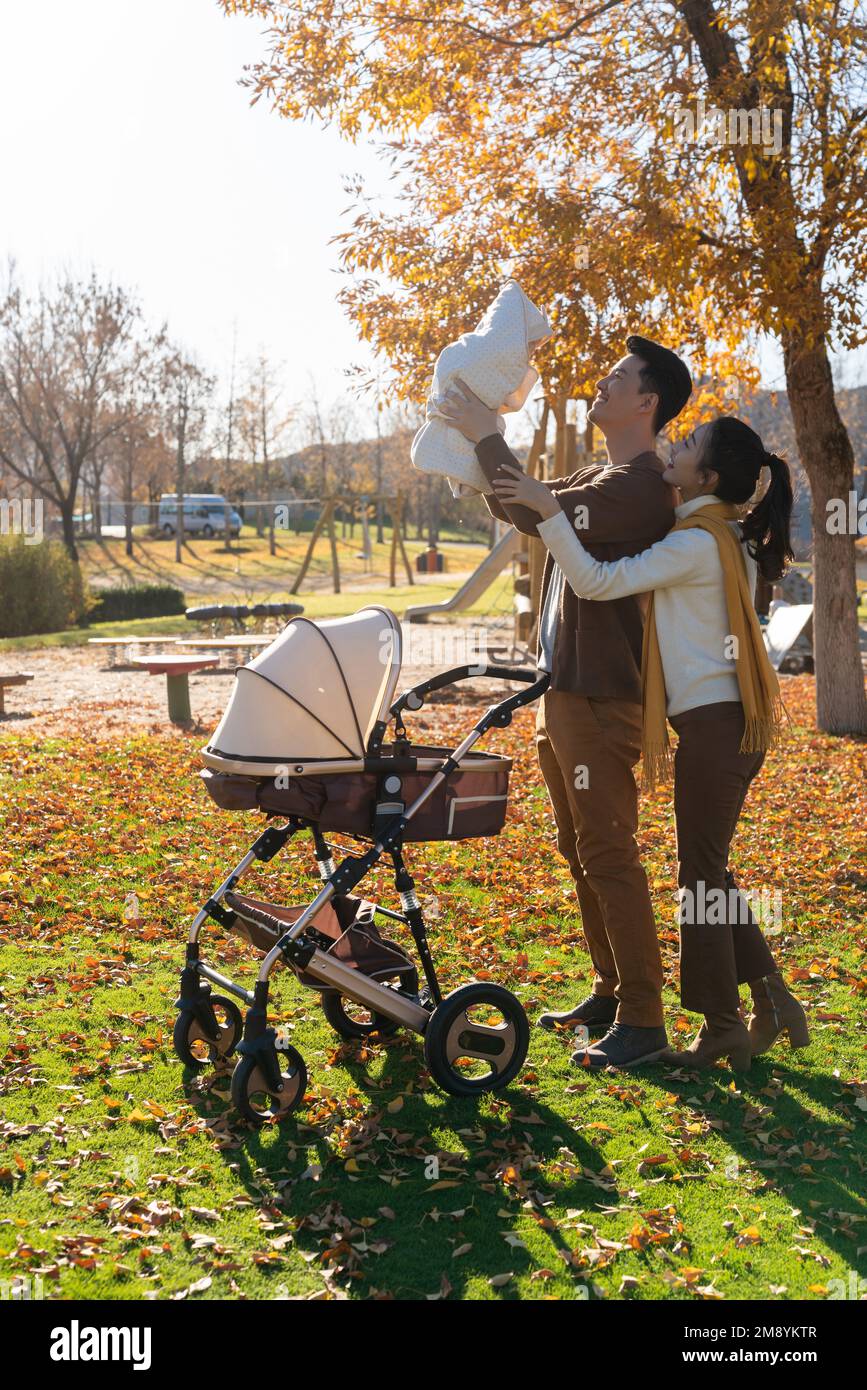 A young couple walk pushing a stroller Stock Photo - Alamy