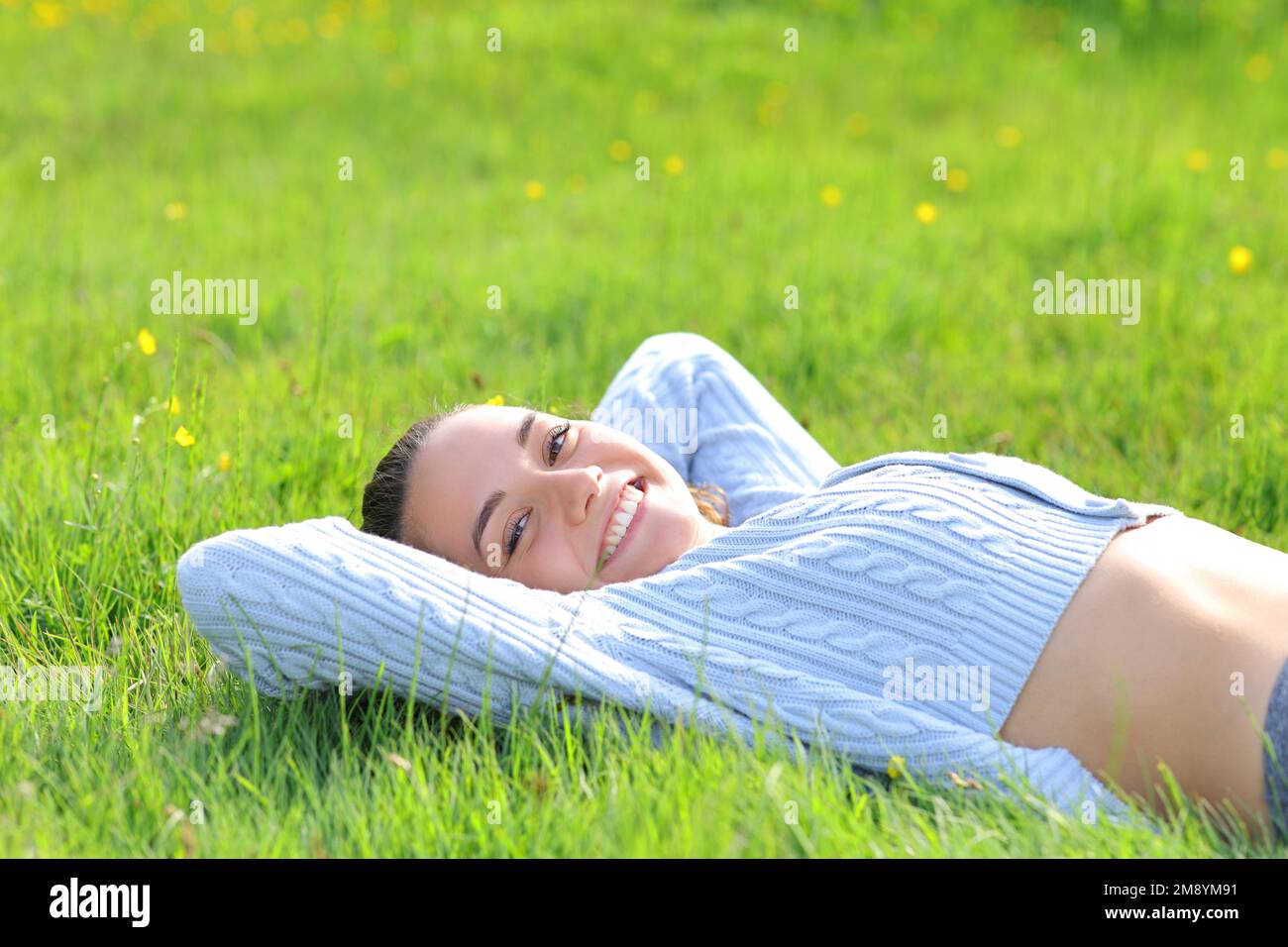 Casual happy woman lying on the grass in nature Stock Photo - Alamy
