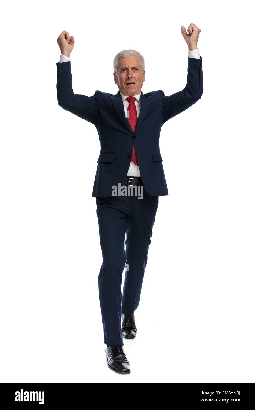 Full body picture of an excited old businessman walking to the camera ...