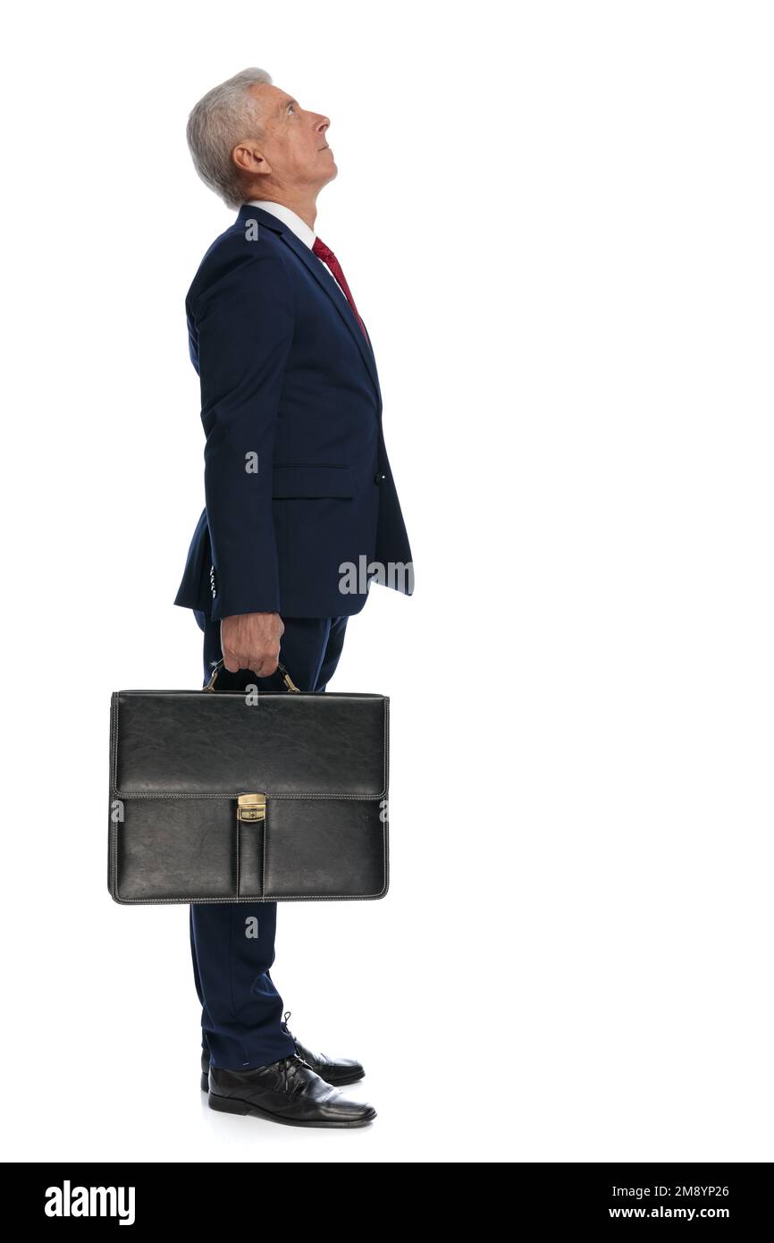 Full body picture and side view of an old businessman looking up while ...