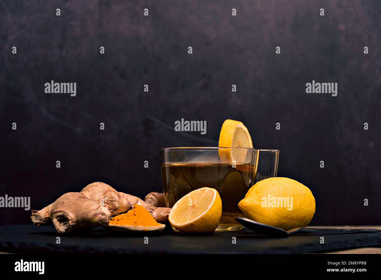 Cup of spiced tea with cinnamon sticks, anise star, lemon and jinger on ...