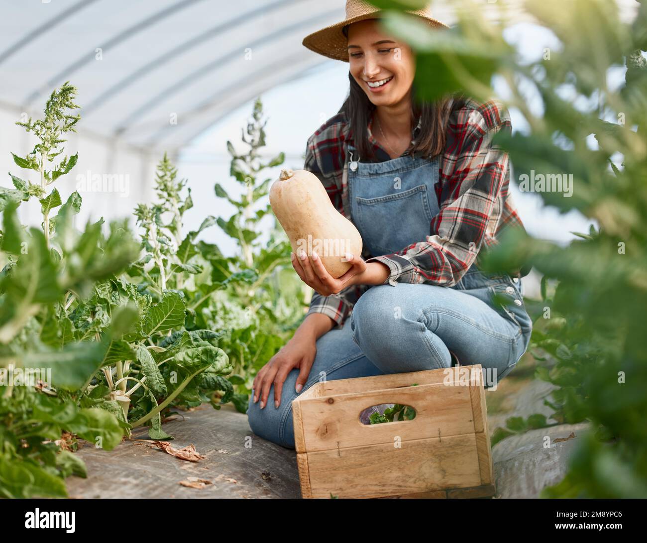 Look at how big this has grown. a young woman holding a butternut while ...