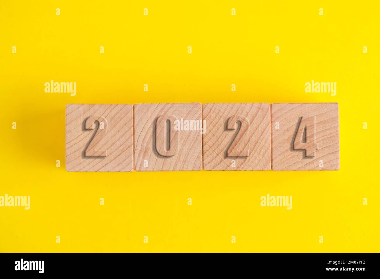 Wooden cubes with numbers 2024 yellow background Stock Photo - Alamy