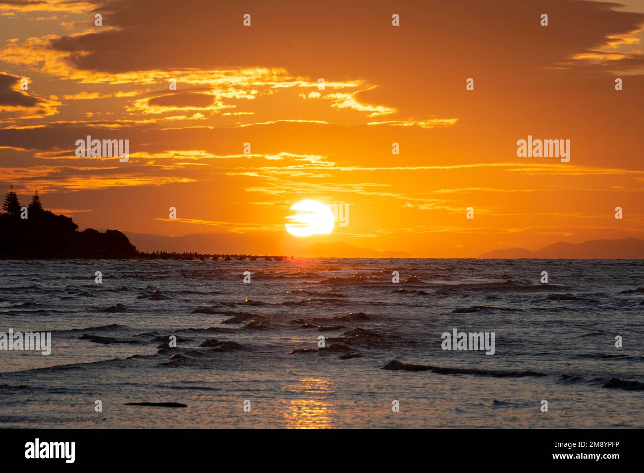 Sun setting over beach at Waikanae, Kapiti District, North Island, New ...