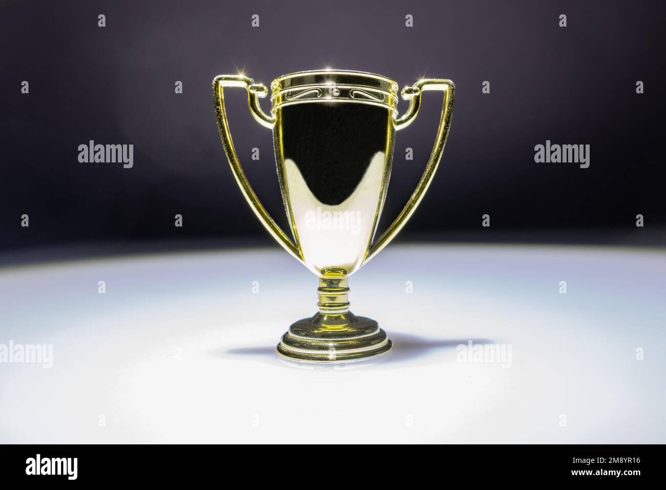 golden cup in white spotlight Stock Photo - Alamy